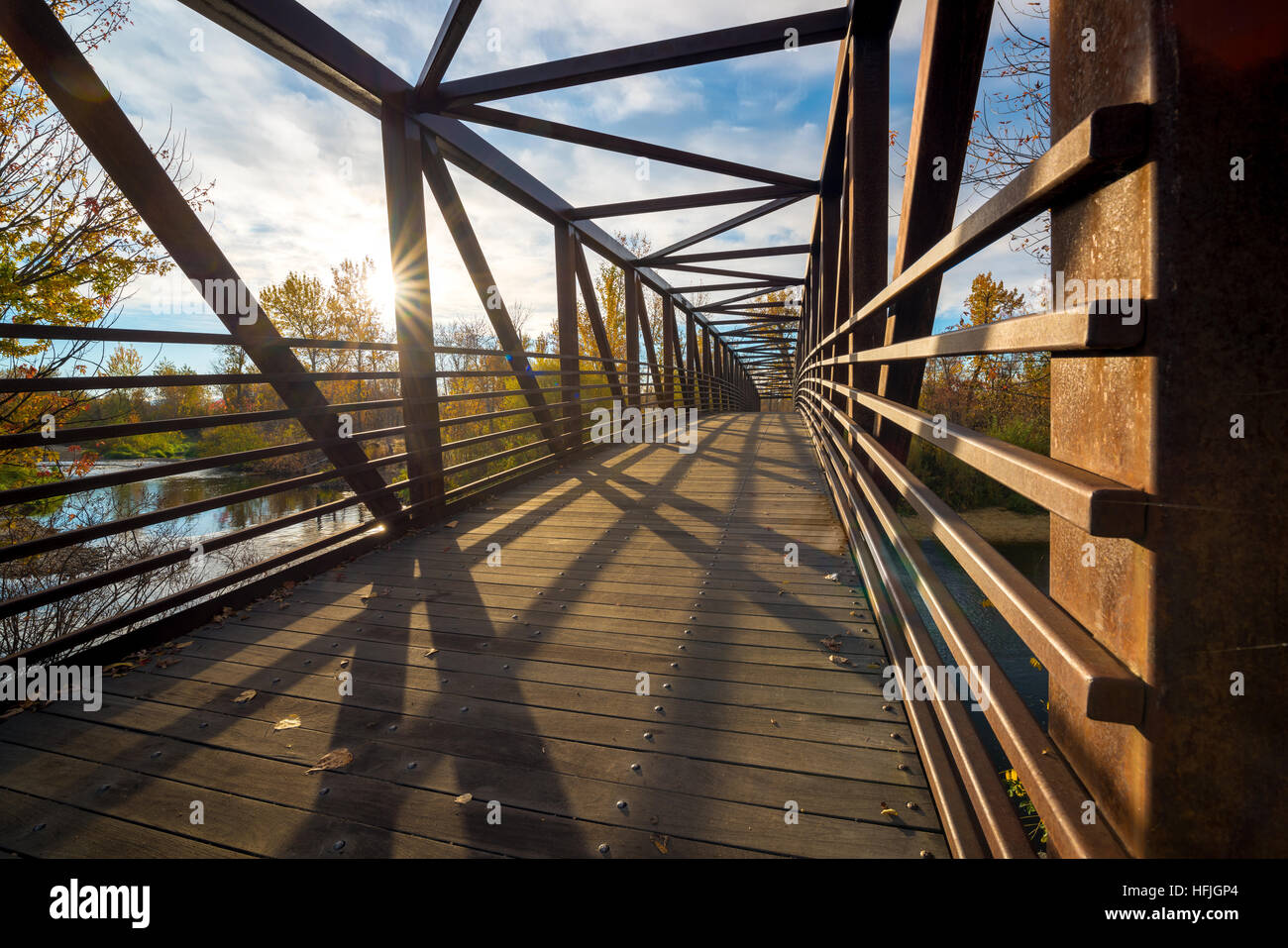 Morning sun star shines on a river foot bridge Stock Photo - Alamy