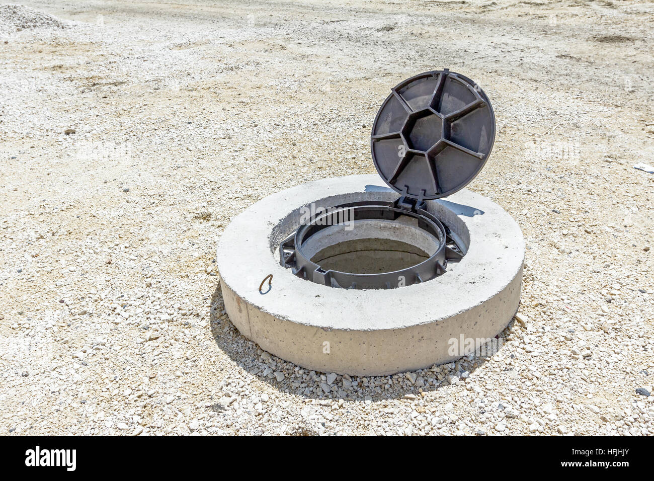 View on assembled new manhole with opened metal cover at construction ...