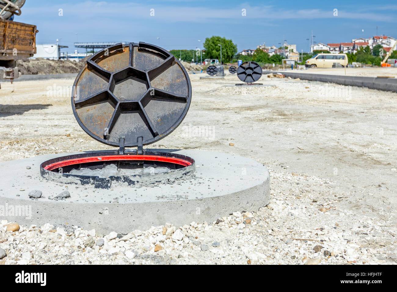 View on assembled new manhole with opened metal cover at construction ...