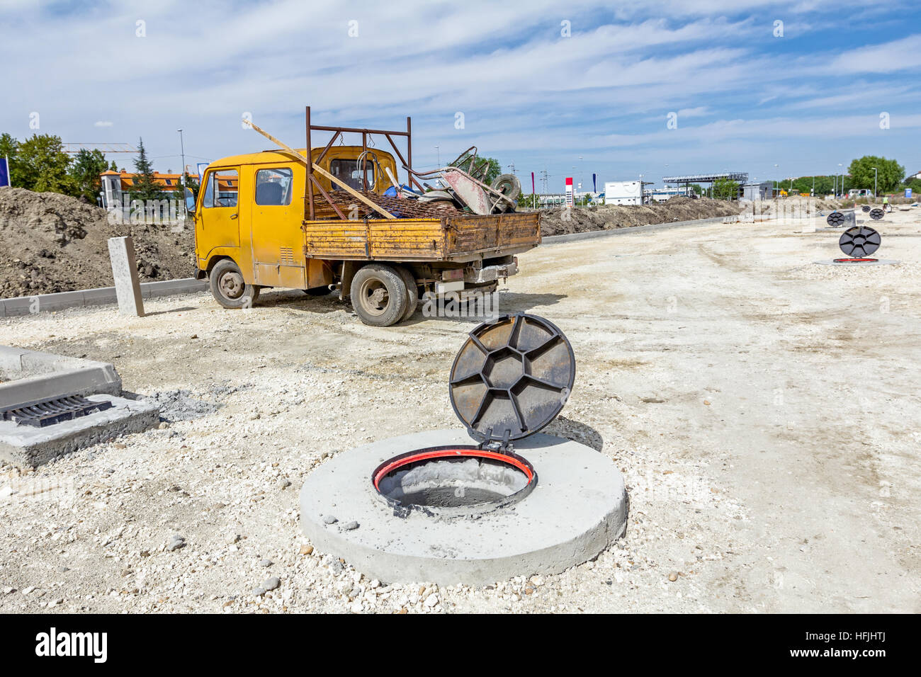 View on assembled new manhole with opened metal cover at construction ...