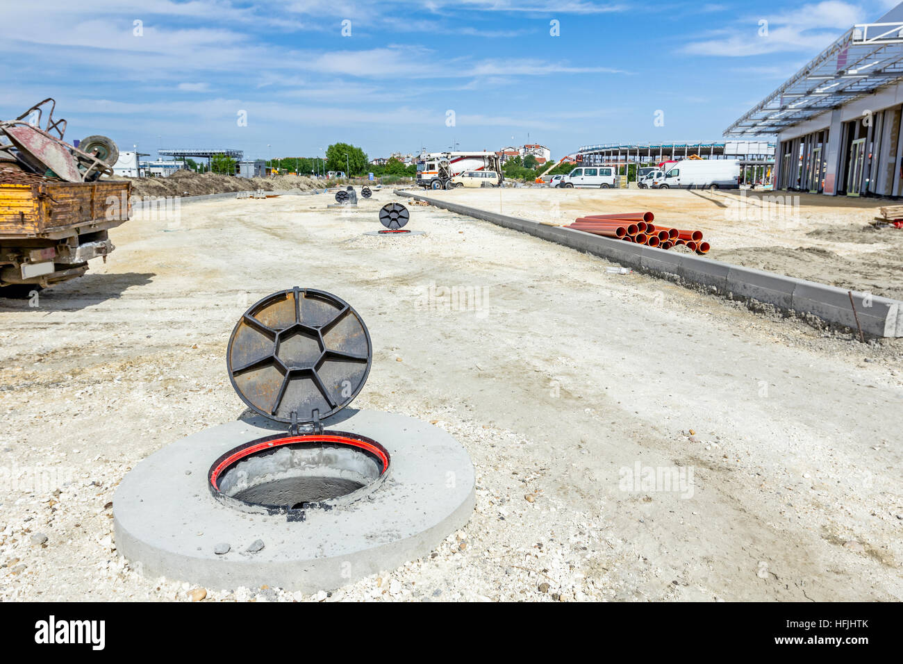 View on assembled new manhole with opened metal cover at construction ...