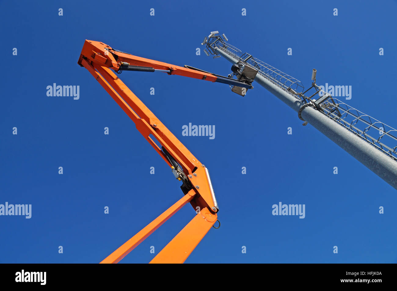 Hydraulic mobile construction platform elevated towards a blue sky with ...