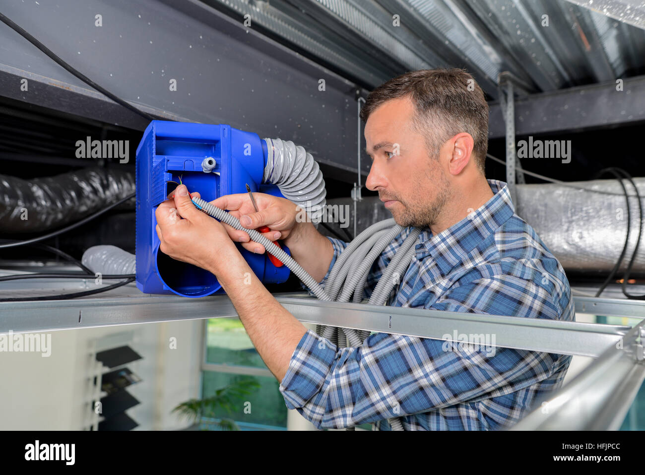 Man repairing ventilation system Stock Photo - Alamy