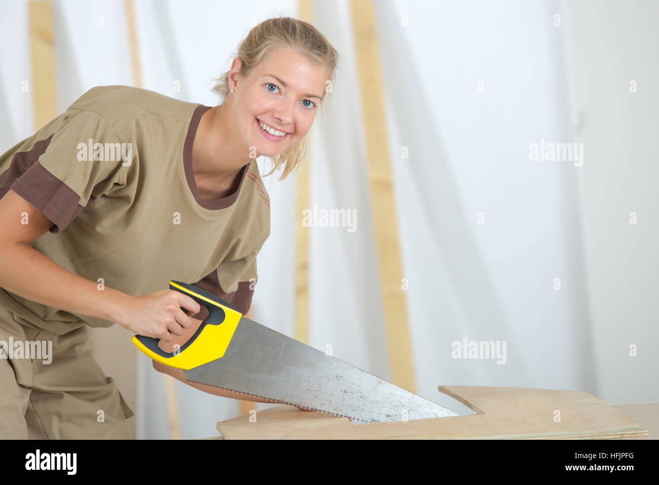 Woman using handsaw Stock Photo - Alamy