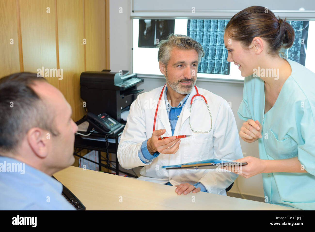 Medical staff with male patient Stock Photo - Alamy