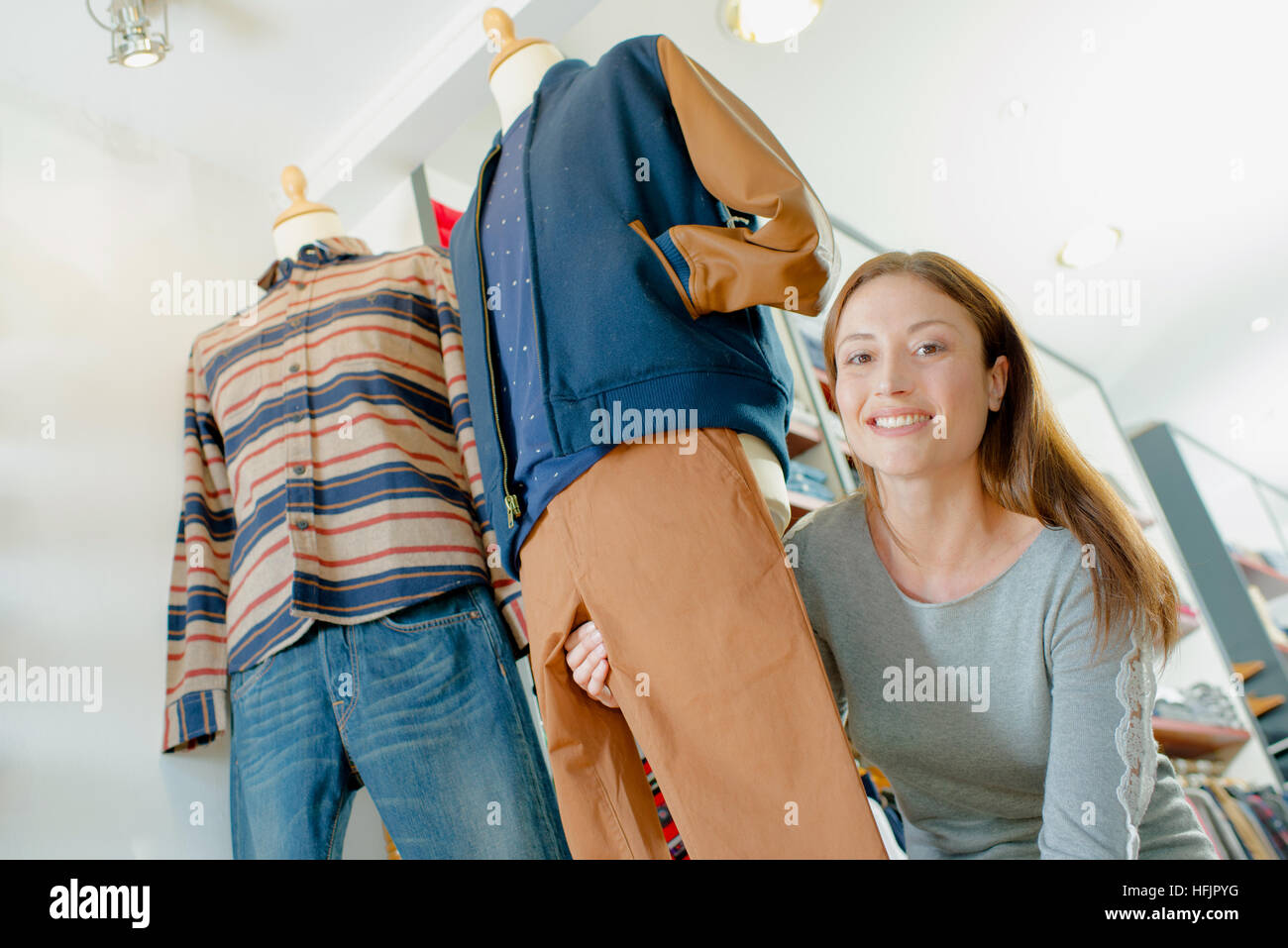 Shop assistant dressing a dummy Stock Photo - Alamy