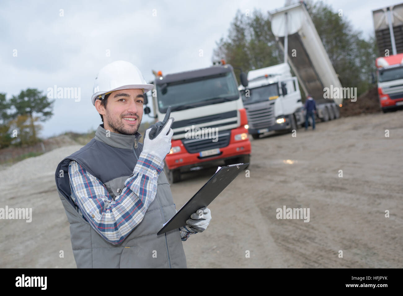 Man using walkie talkie on construction site Stock Photo - Alamy