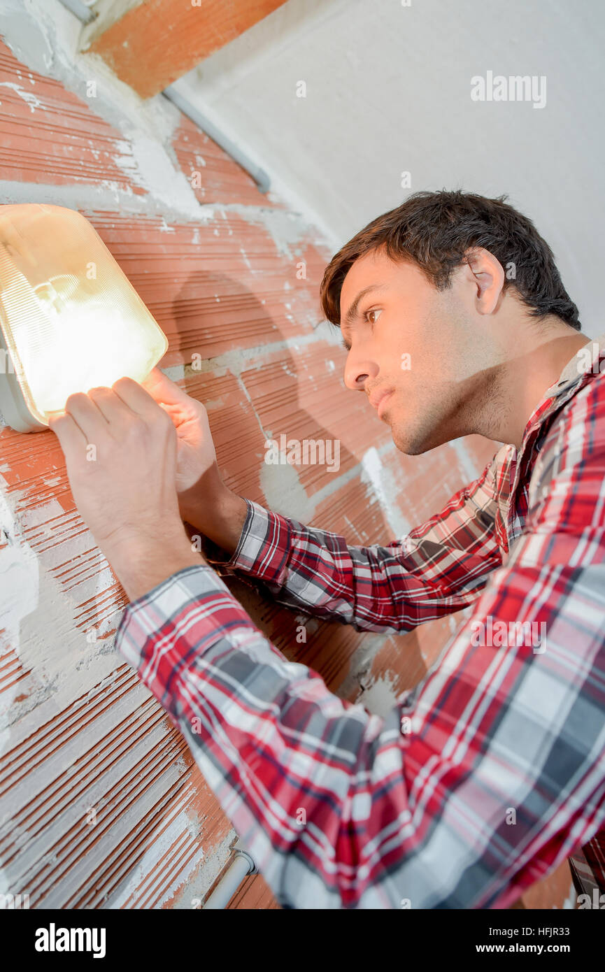 man putting a wall lamp Stock Photo - Alamy