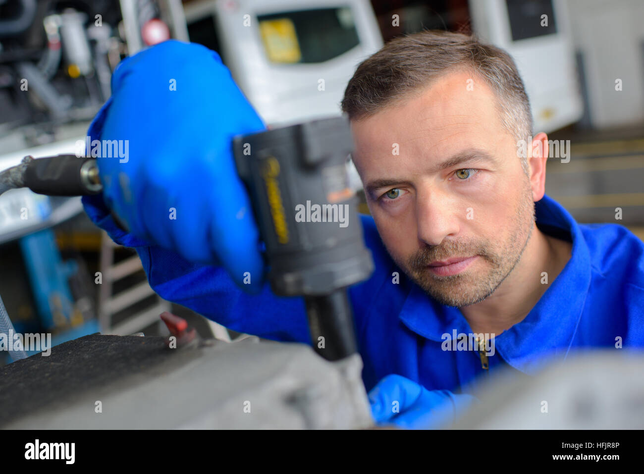 Mechanic using tool Stock Photo - Alamy