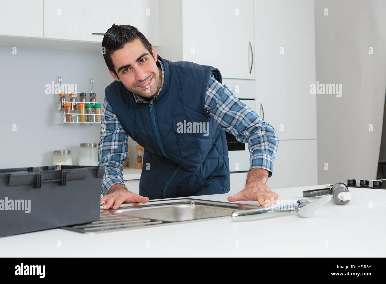 Portrait of man fitting kitchen sink Stock Photo - Alamy