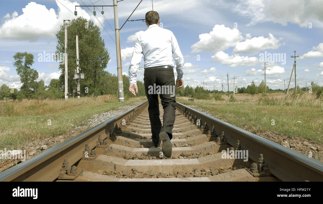 Man walks along railway tracks in the countryside Stock Photo - Alamy