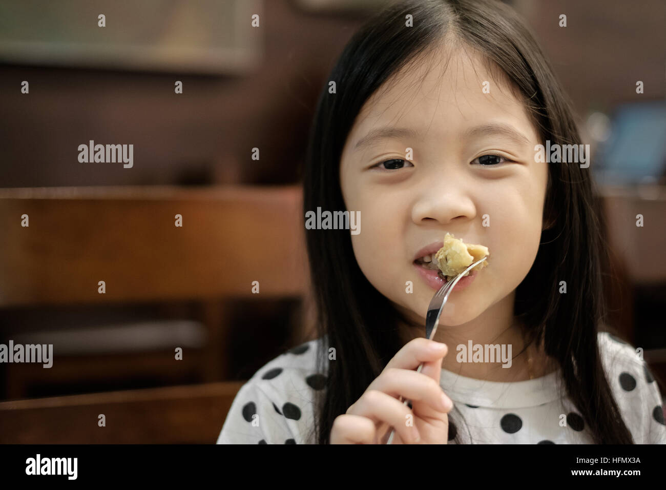 Girl eating pastry snack with smile in vintage Stock Photo - Alamy