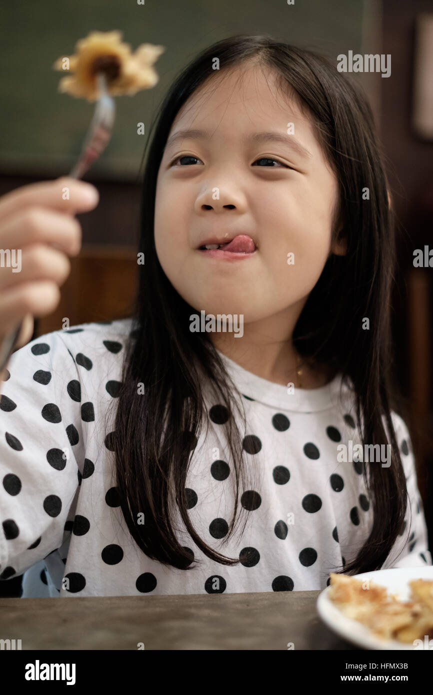 Child eating pastry snack with smile in vintage Stock Photo - Alamy