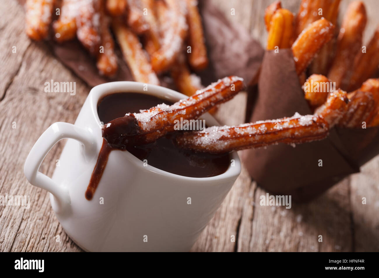 Spanish churros with a cup of hot chocolate on a table. Horizontal ...
