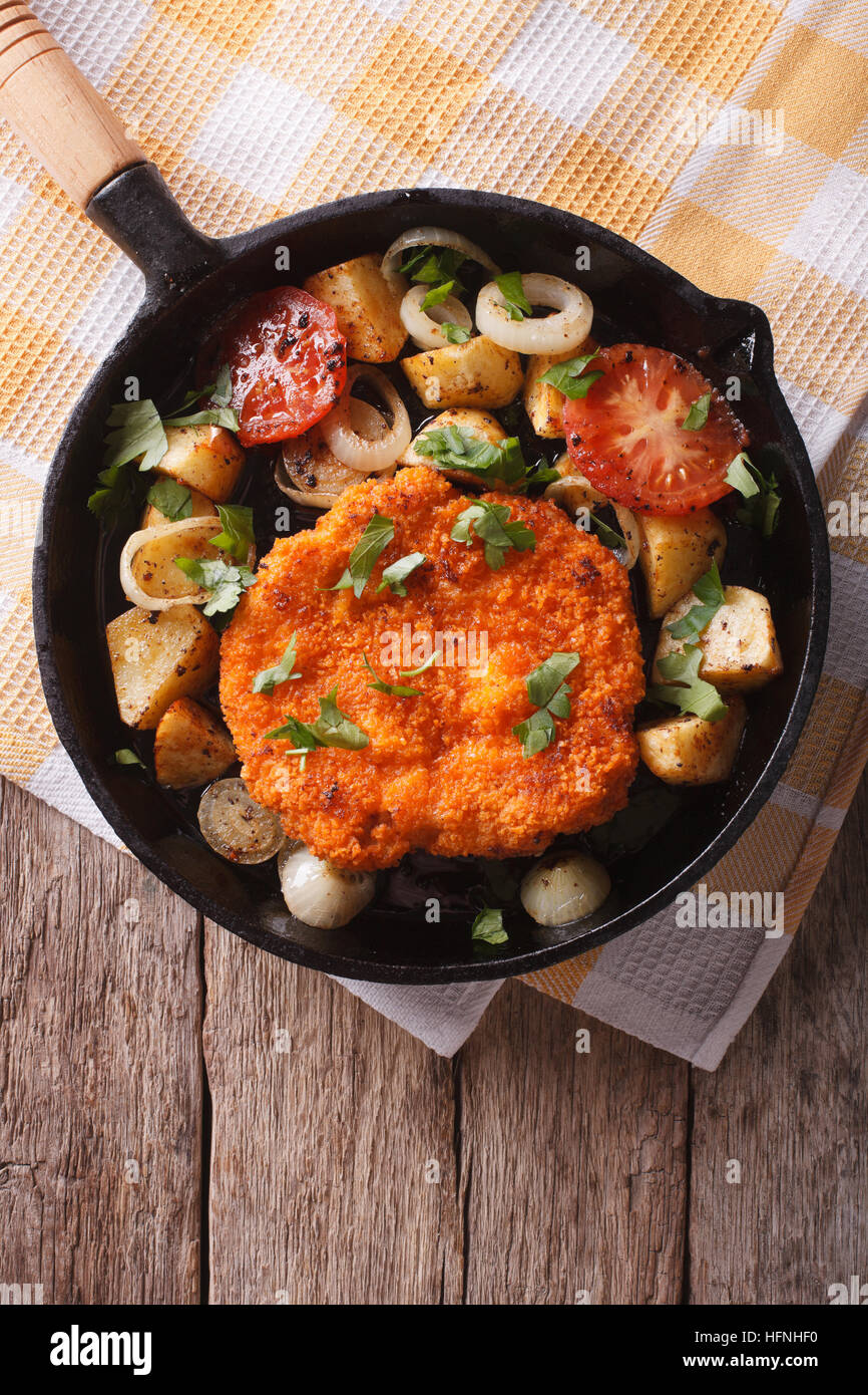 breaded German Weiner schnitzel with fried vegetables in a pan on the ...