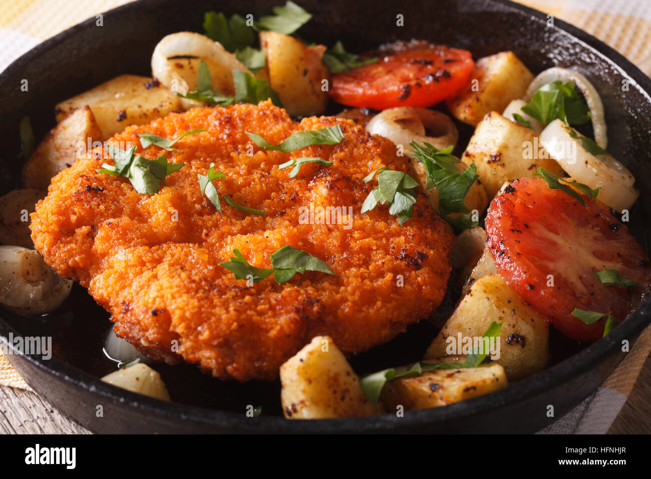 schnitzel with fried vegetables in a pan close-up on the table ...