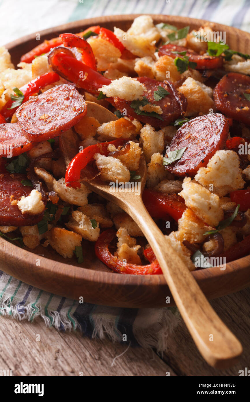 Spanish migas with chorizo and vegetables close-up on a plate. vertical ...