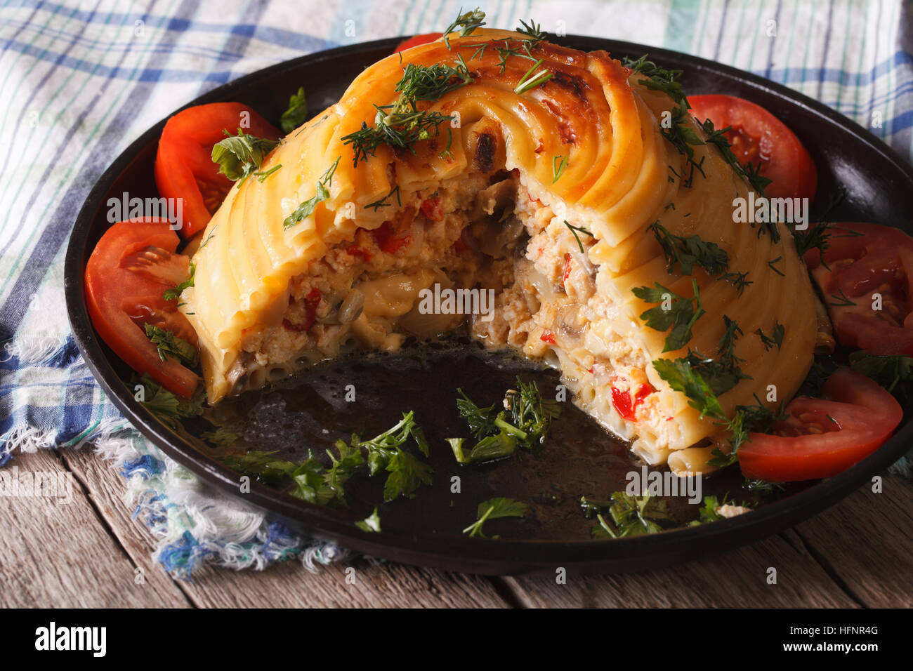 French timbale of pasta stuffed with chicken and vegetables close up on ...