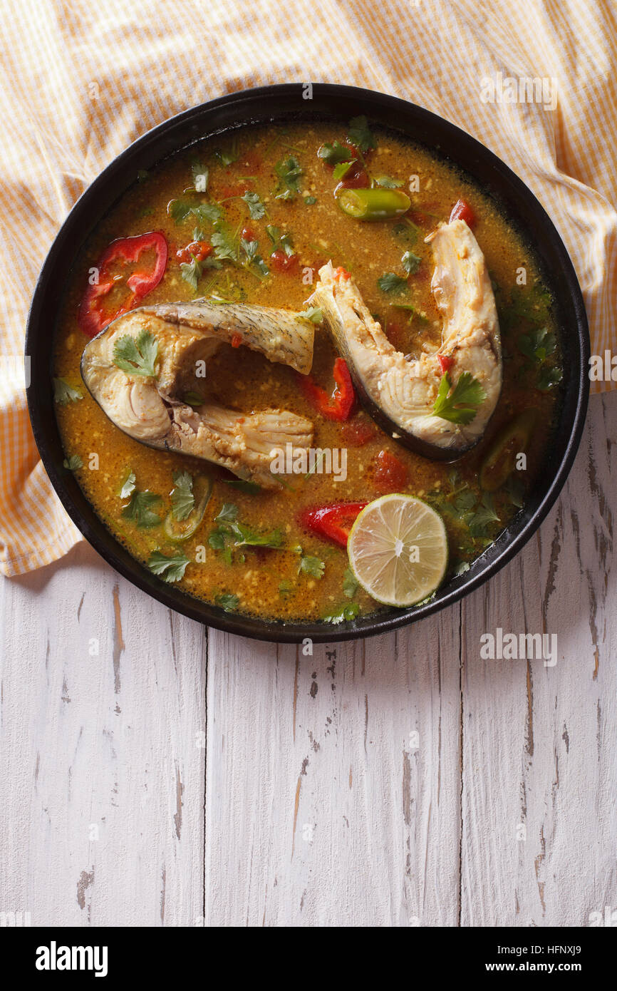 Delicious spicy fish curry with cilantro on the table. vertical top ...