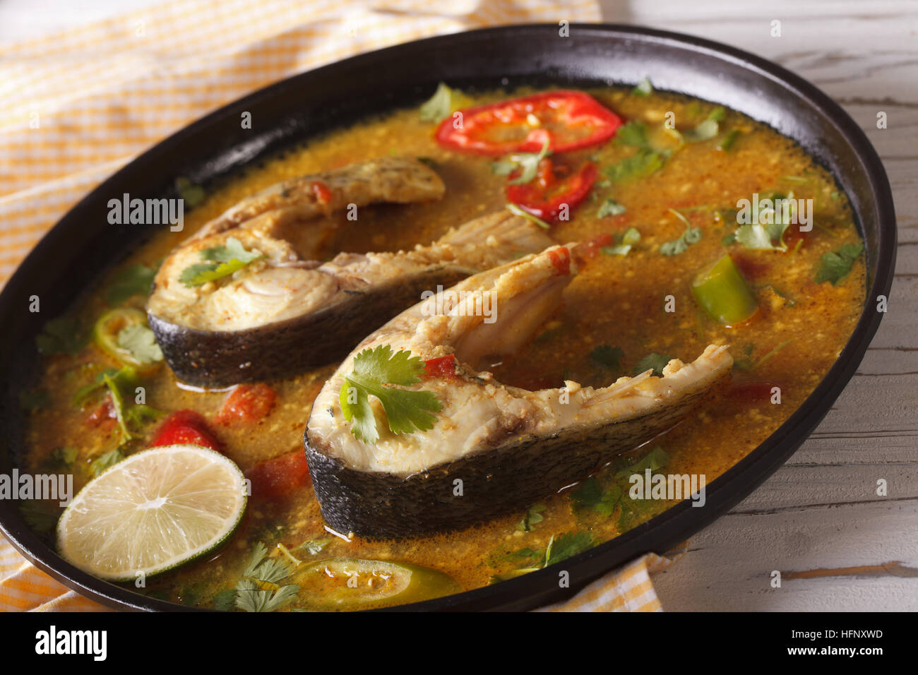 Spicy hot fish curry with vegetables close-up on a plate. horizontal ...