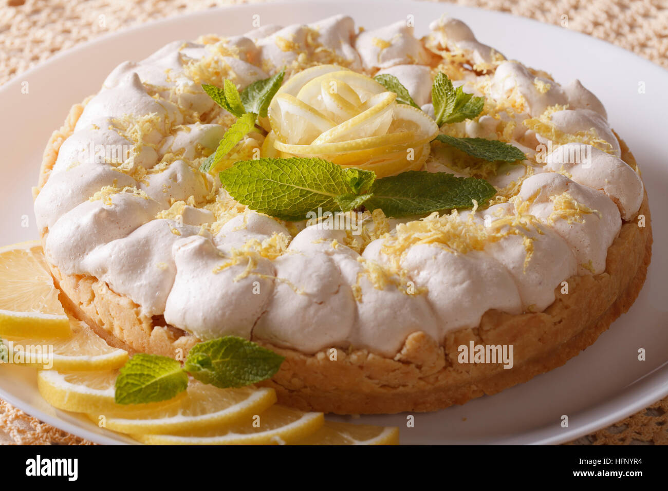 Gourmet Lemon cake with meringue and mint close-up on a plate ...