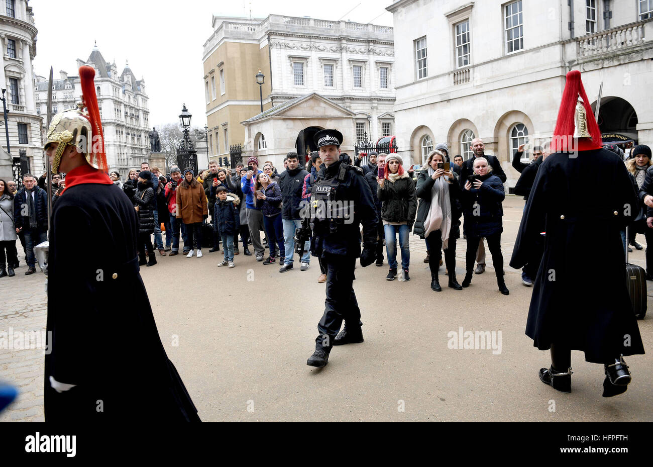 A armed police officer walks amongst tourists at Horse Guards Parade in ...