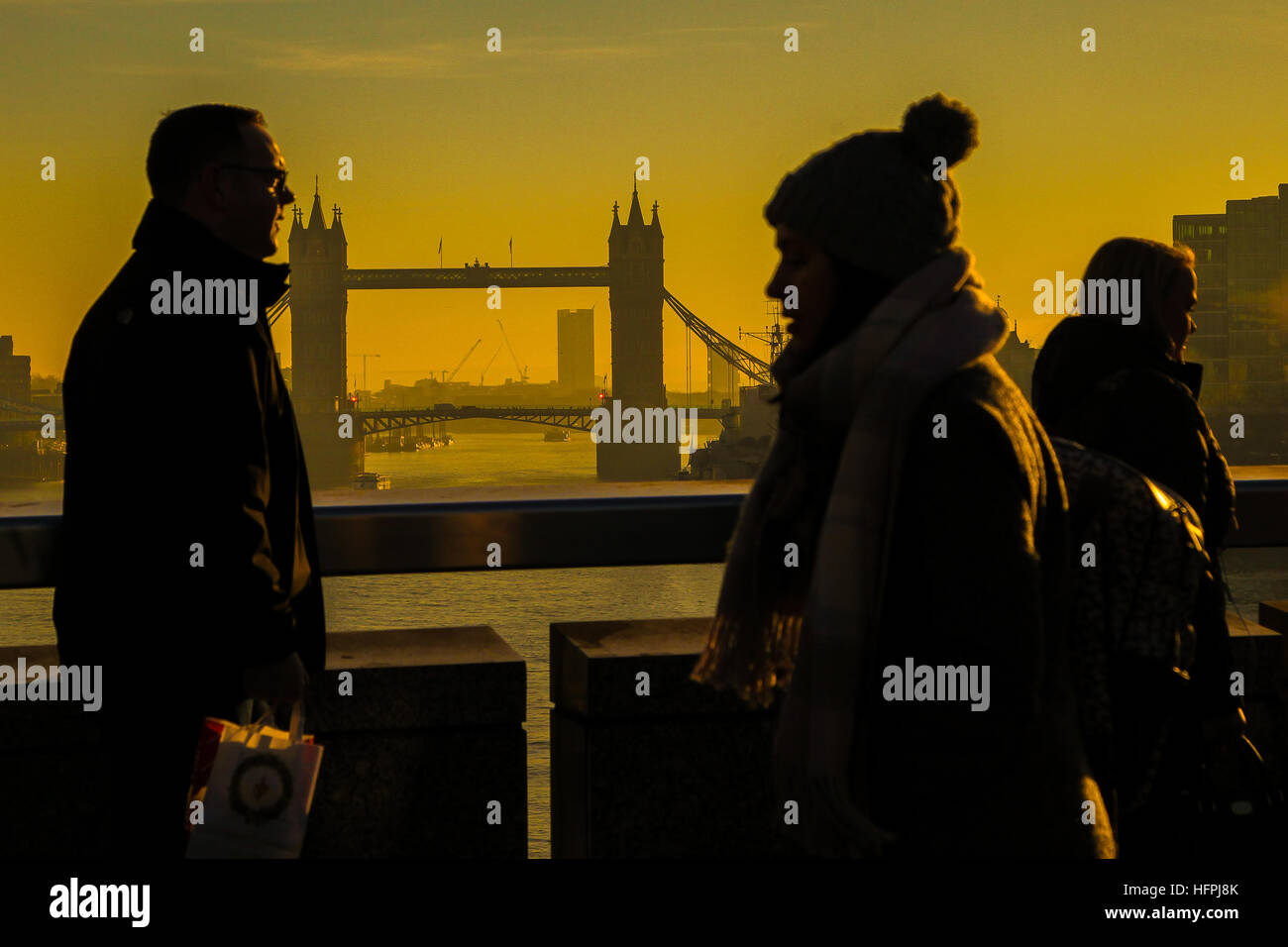 Commuters walk over London Bridge on a cold sunny morning with freezing ...