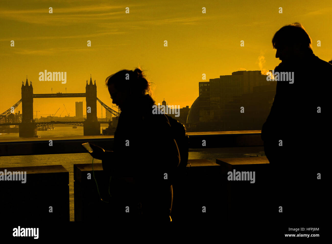 Commuters walk over London Bridge on a cold sunny morning with freezing ...