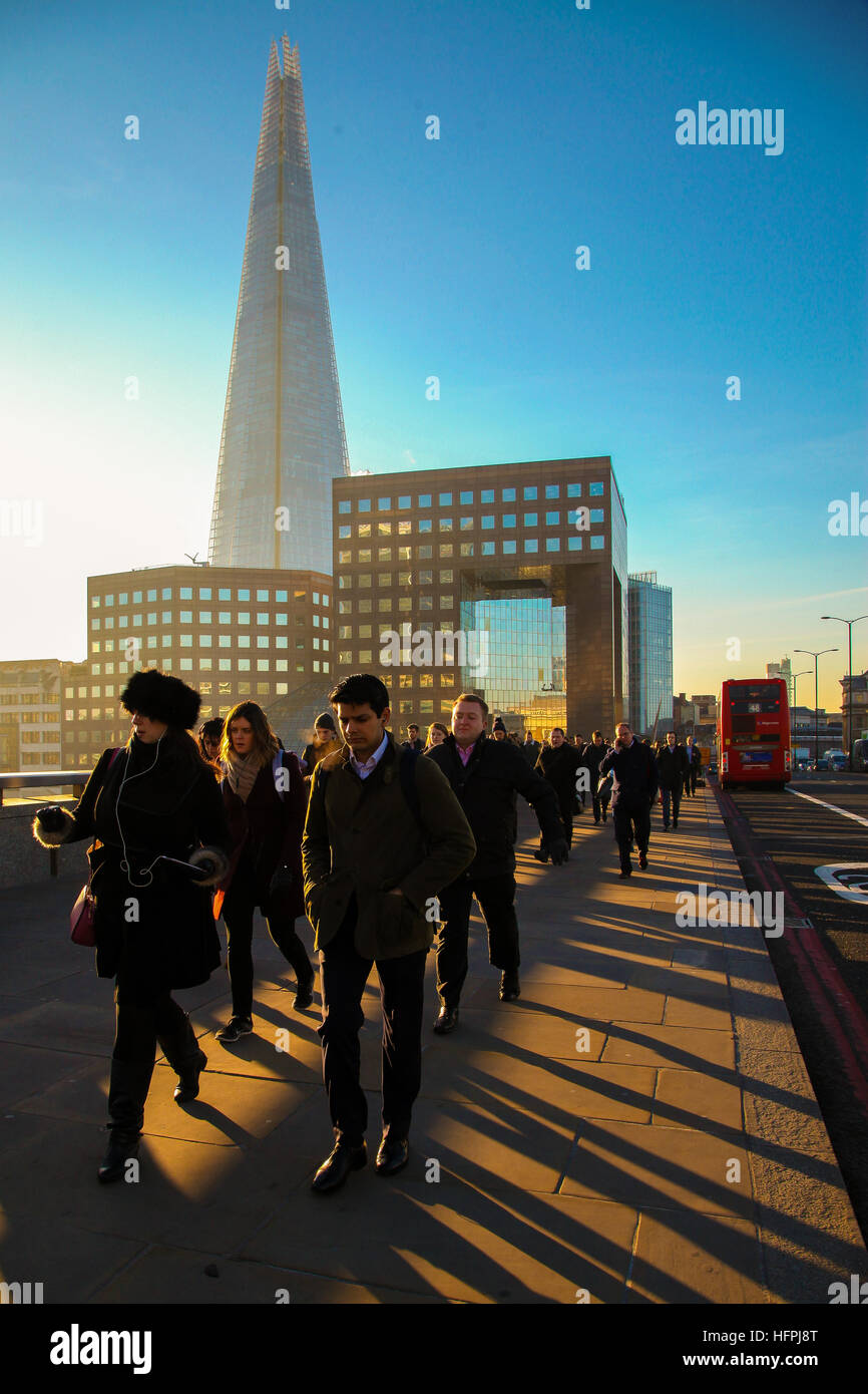 Commuters walk over London Bridge on a cold sunny morning with freezing ...