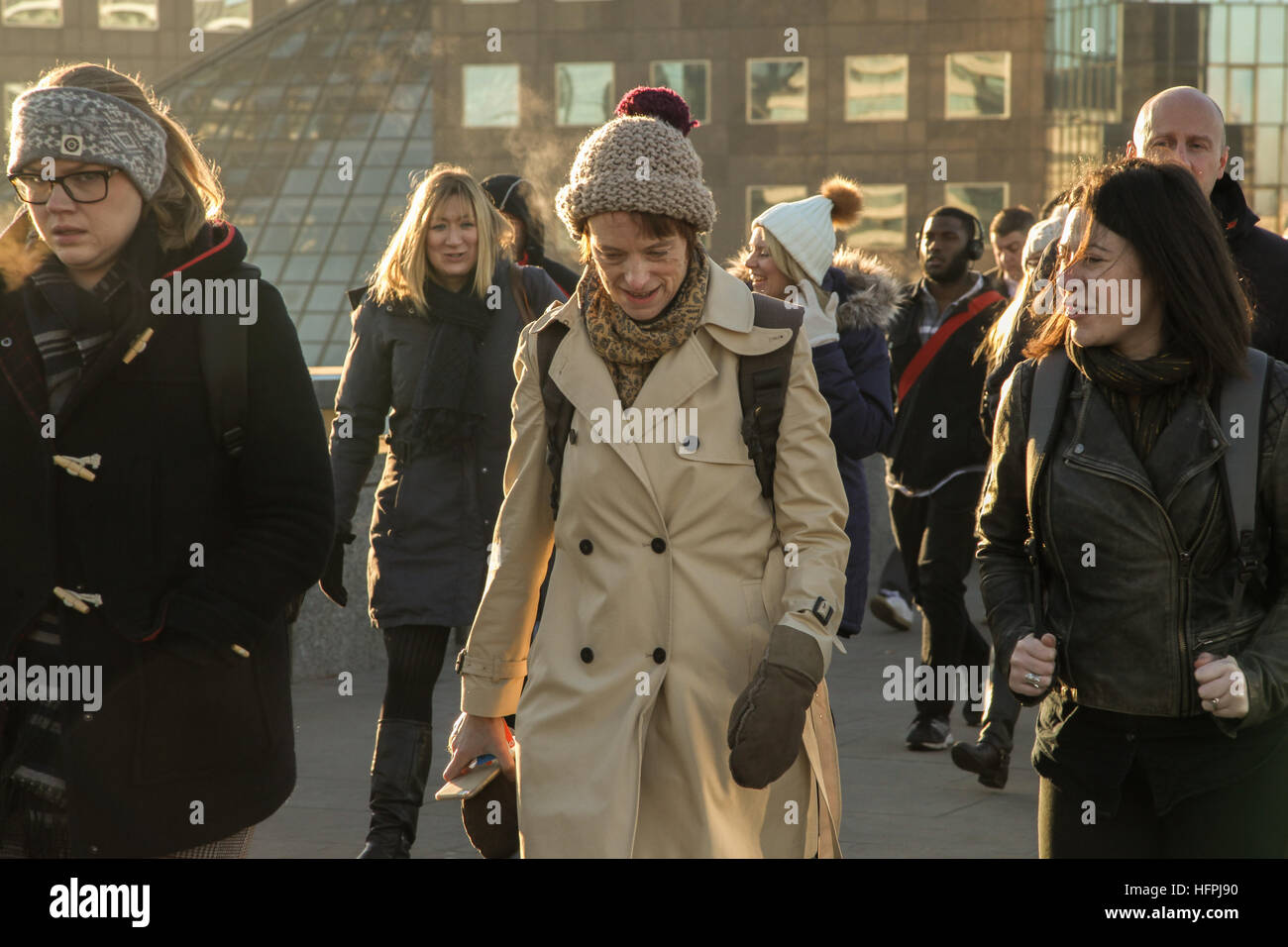Commuters walk over London Bridge on a cold sunny morning with freezing ...