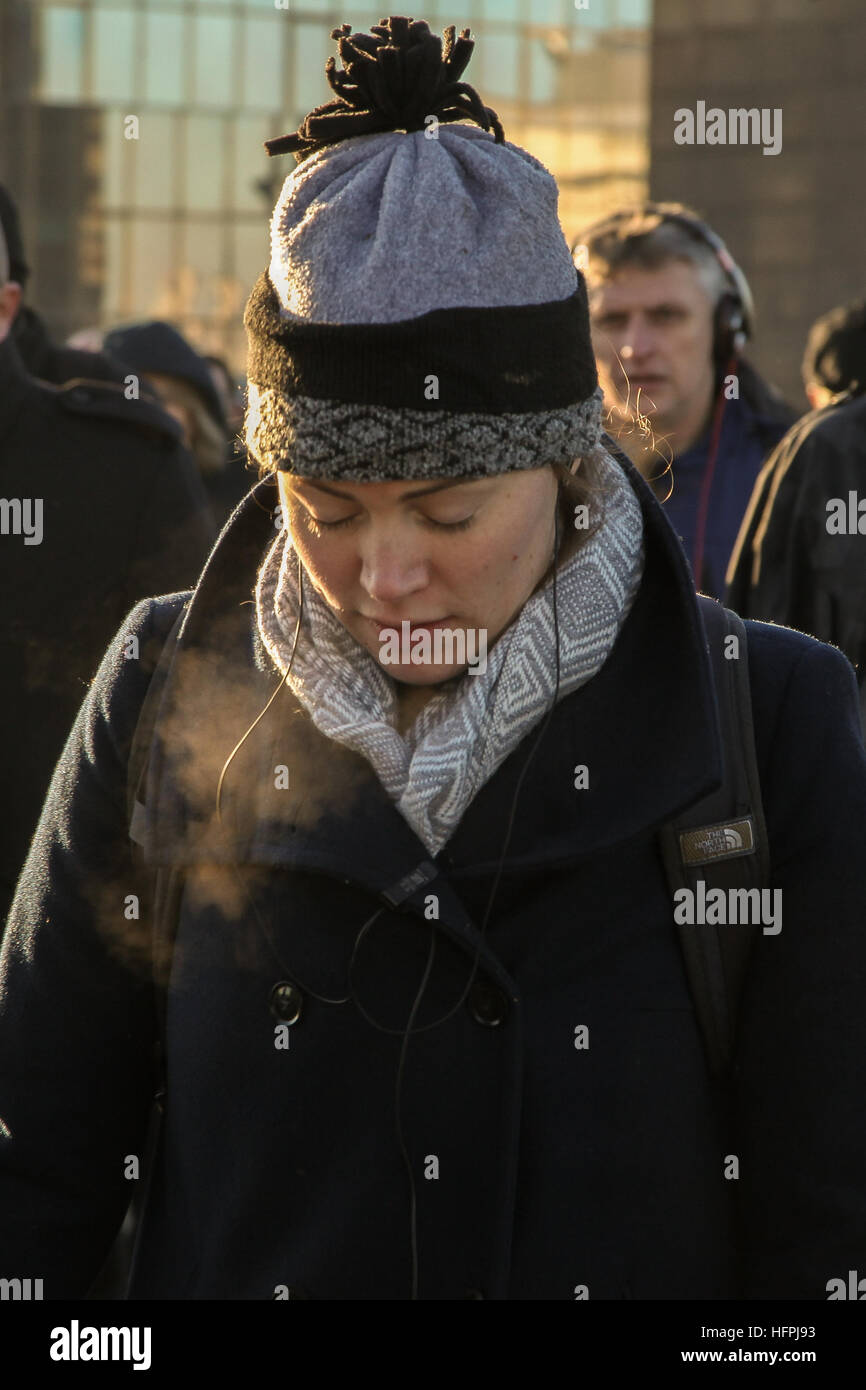 Commuters walk over London Bridge on a cold sunny morning with freezing ...