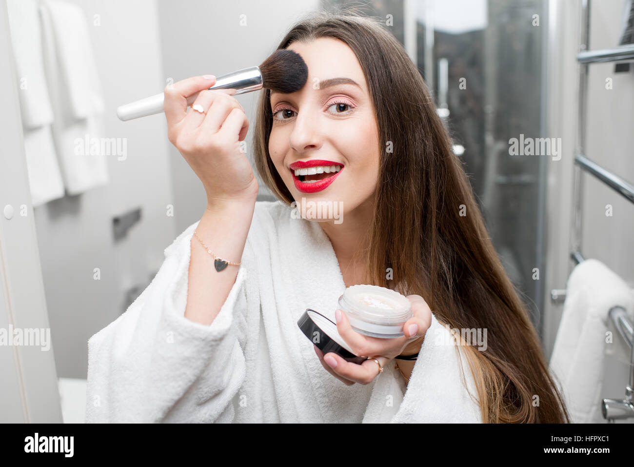 Woman applying makeup Stock Photo - Alamy