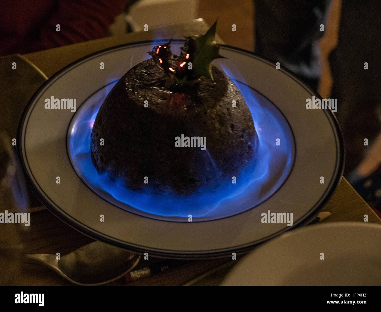 Flaming Christmas pudding with holly Stock Photo - Alamy