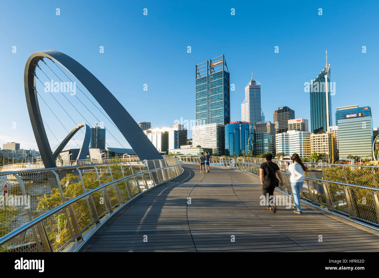 People crossing the Elizabeth Quay pedestrian bridge with the city ...