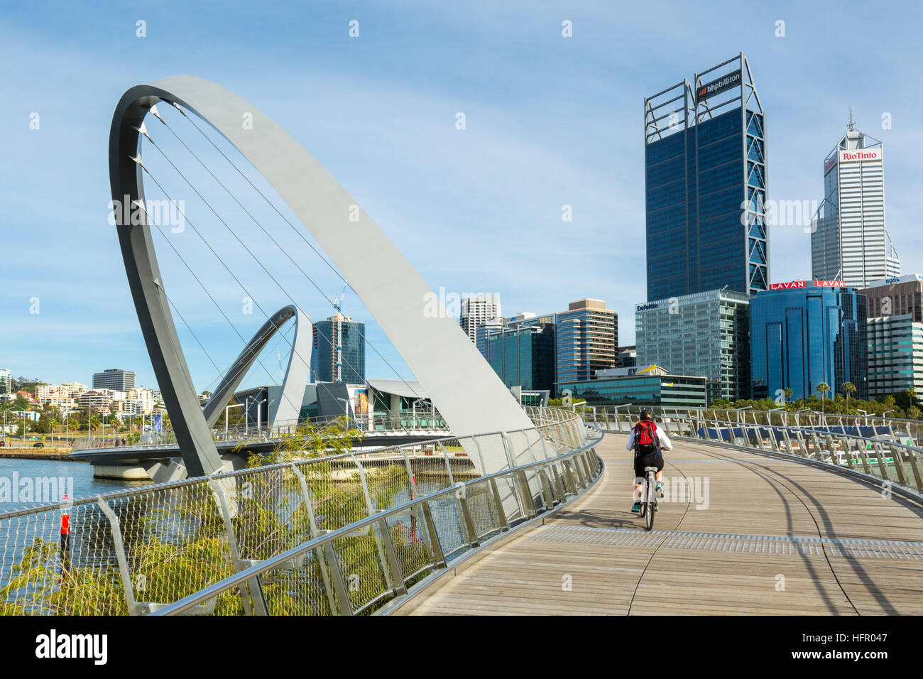 Early morning cyclist crossing the Elizabeth Quay pedestrian bridge ...