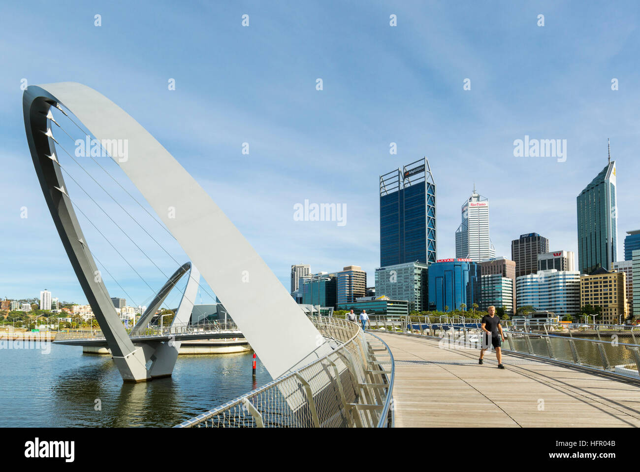 Early morning walker crossing the Elizabeth Quay pedestrian bridge with ...