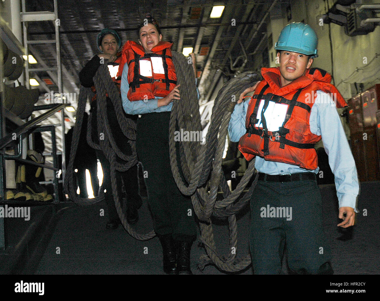 Deck Department Sailors move mooring lines to the well deck aboard USS ...