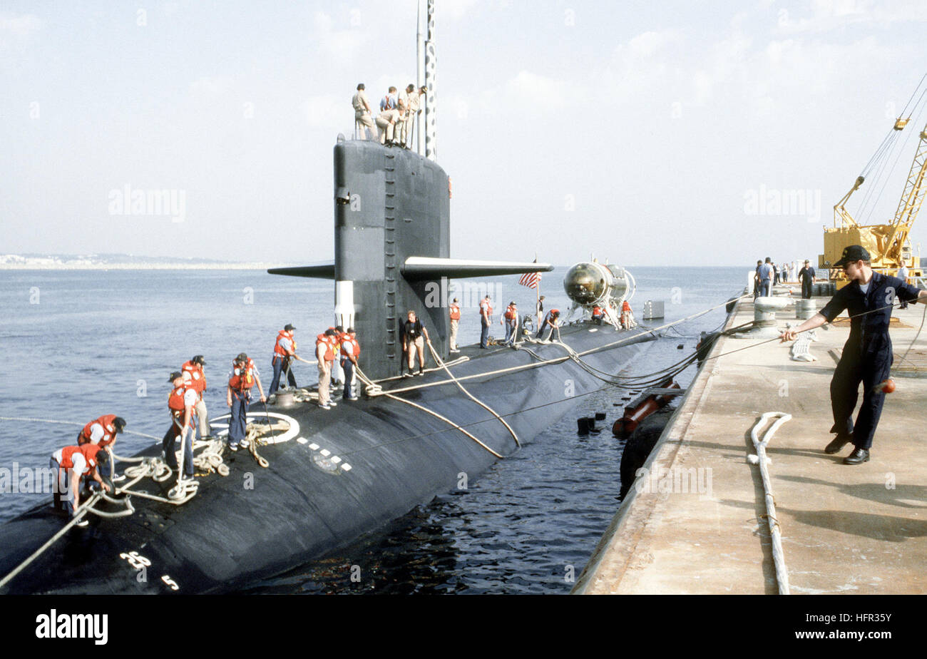 Crewmen work to secure mooring lines on the deck of the nuclear-powered ...
