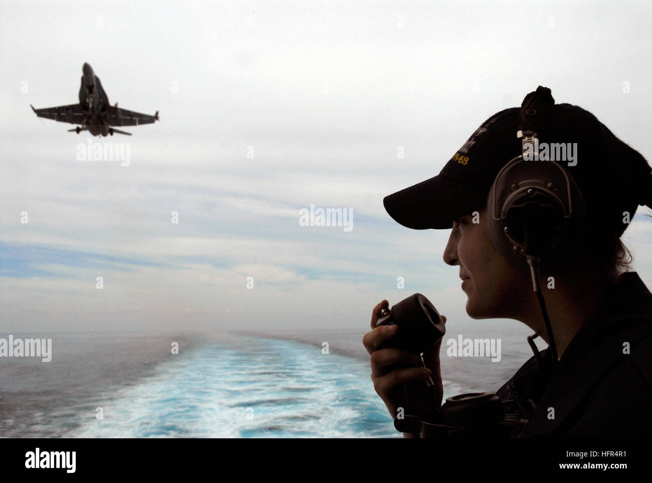 Seaman on aft lookout communicates via sound-powered phone while an F/A ...