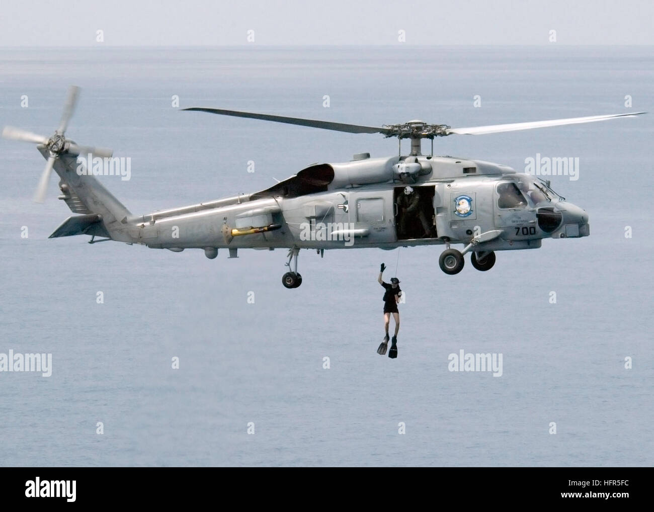 Aviation Warfare Operator 3rd Class suspended from a rescue hoist on SH ...