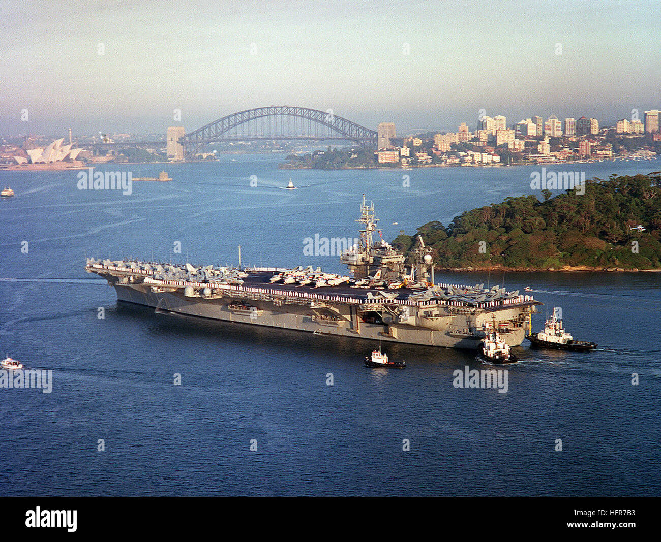 A port side view showing US Navy (USN) Sailors manning the rails of the ...