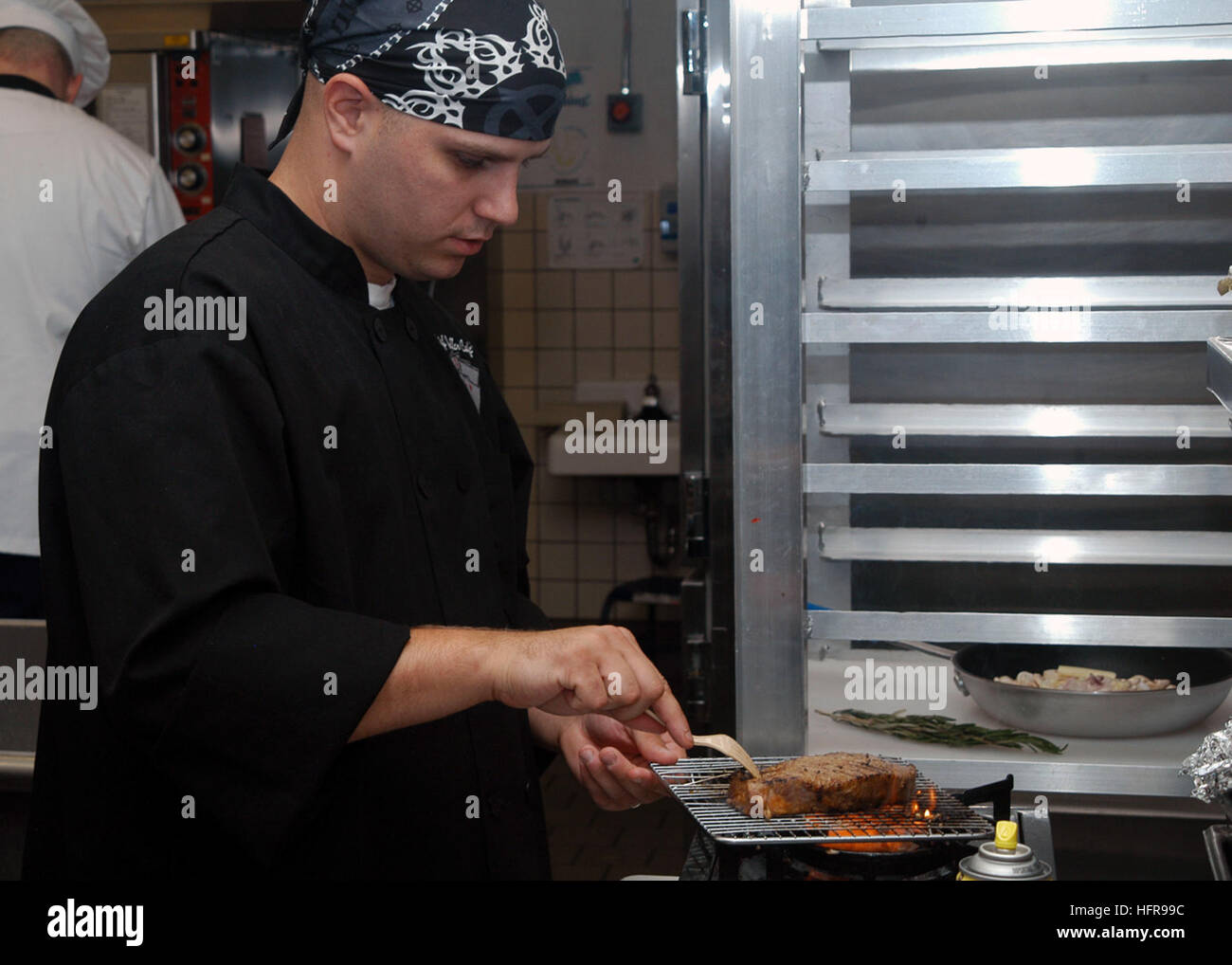060825-N-3973P-004 Specialist 3rd Class Steven Mize grills a steak for ...