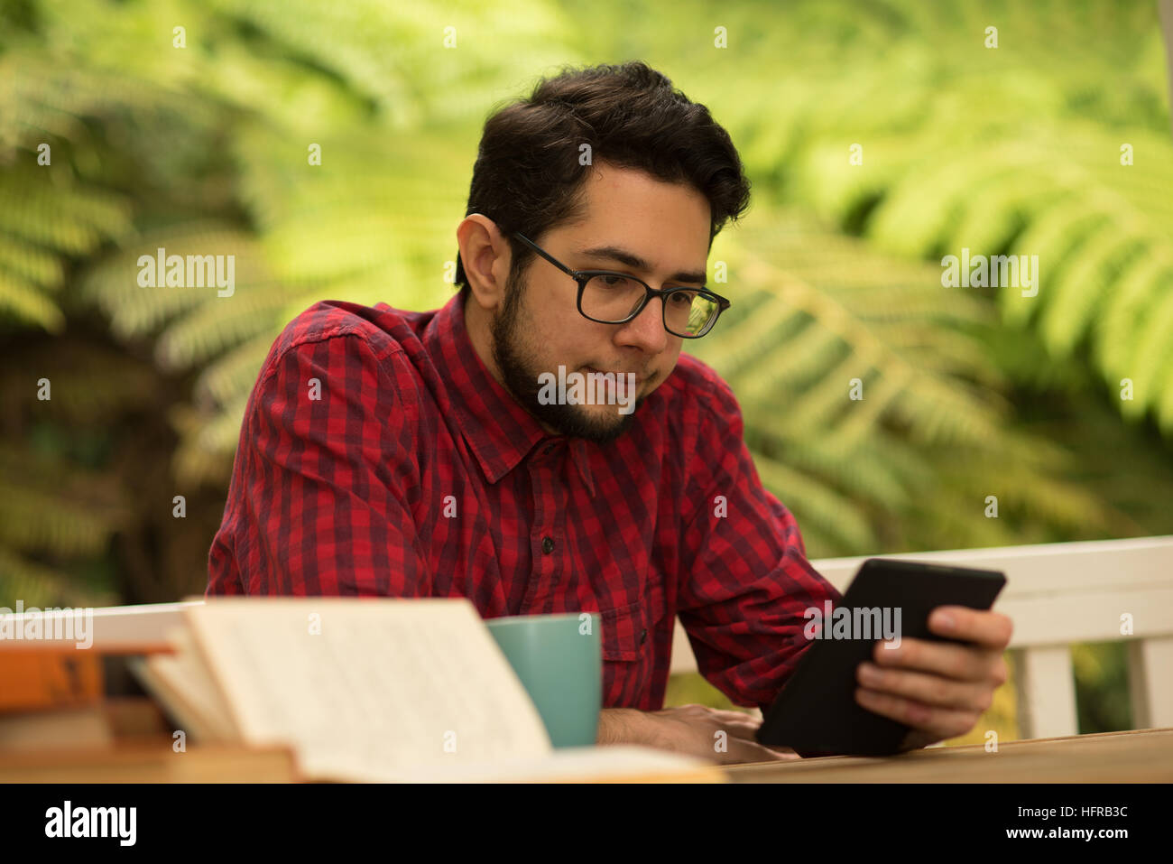 Young man with reader sitting outdoor Stock Photo - Alamy