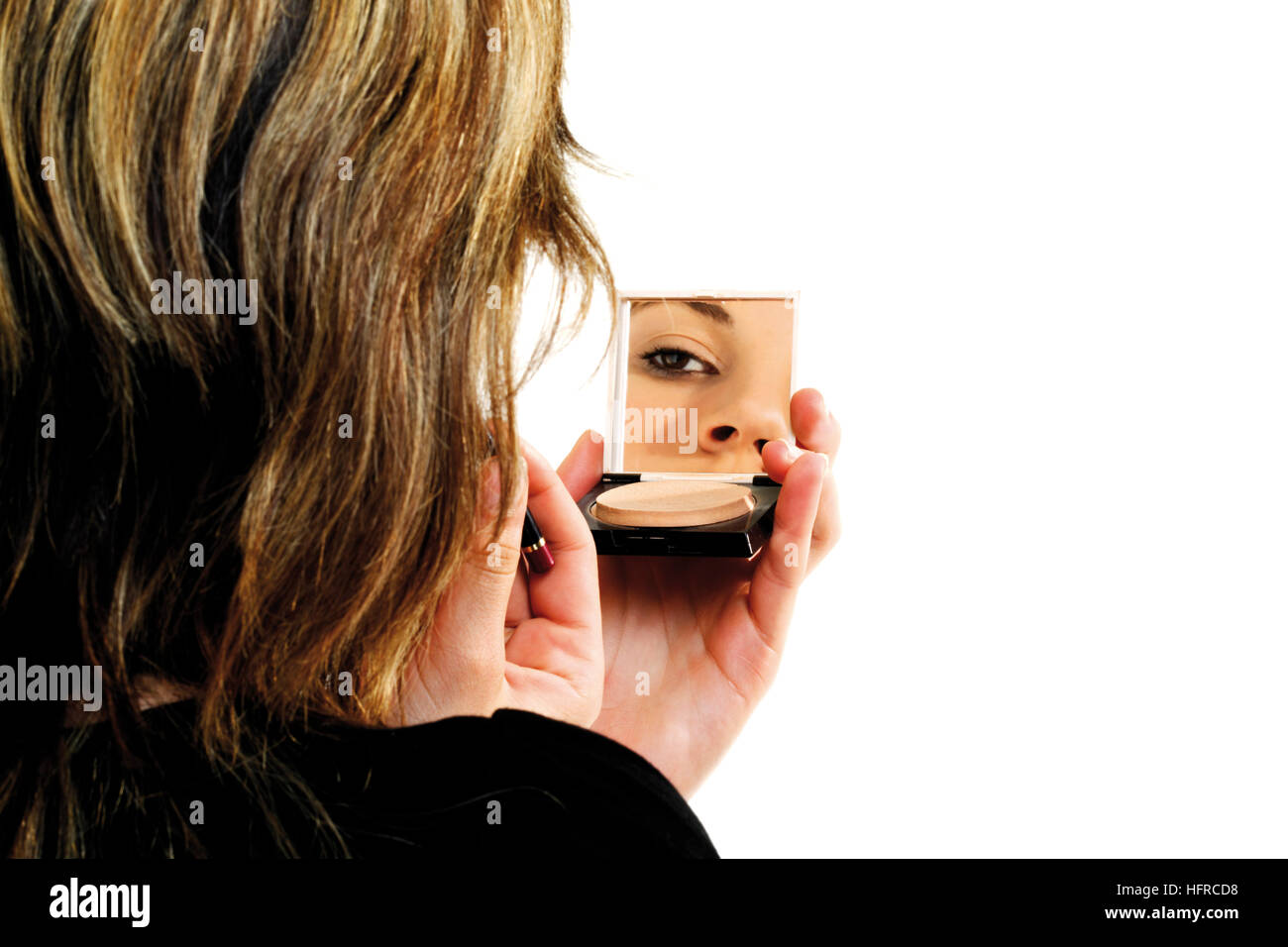 Young woman looking into compact mirror Stock Photo - Alamy