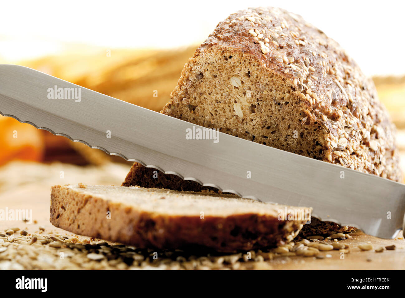 Knife slicing wholegrain bread Stock Photo - Alamy
