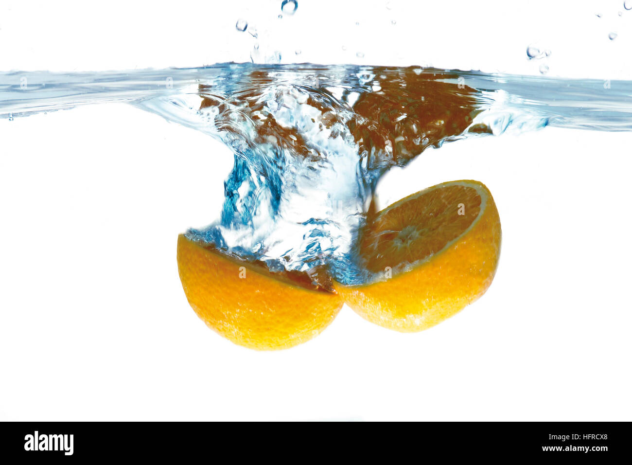 Two orange halves dunked into water Stock Photo - Alamy