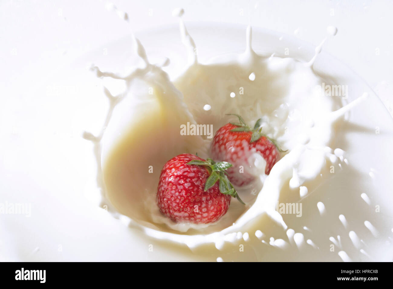 Strawberries falling into milk Stock Photo - Alamy