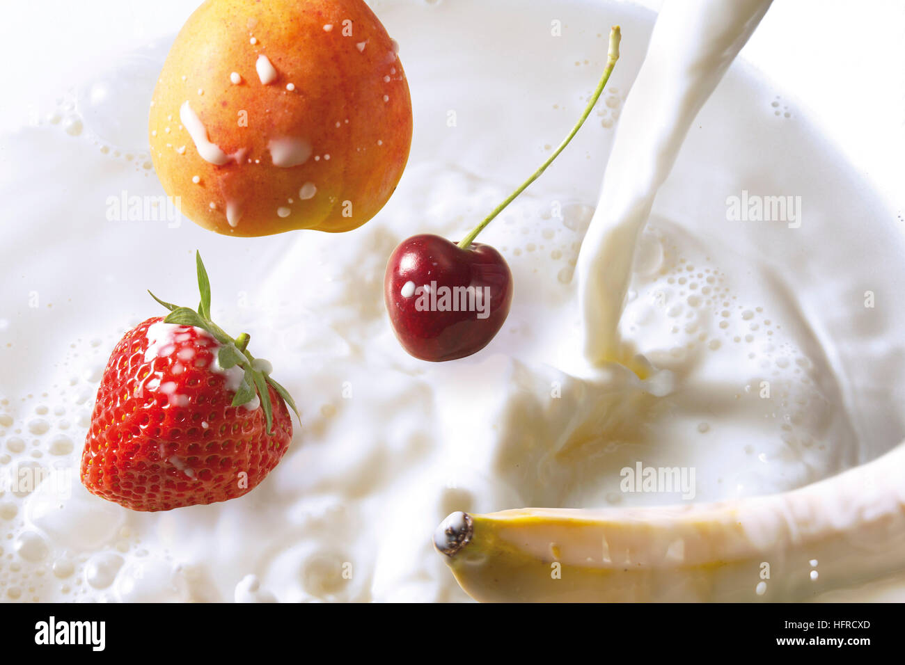 Fruit falling into milk - strawberry, cherry, banana and peach Stock ...