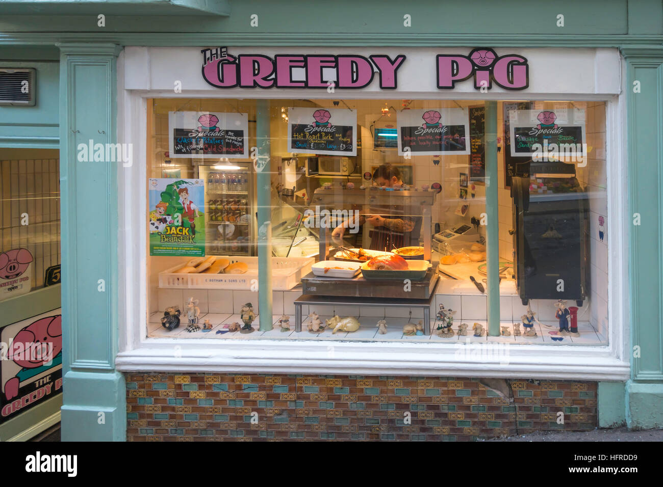 Freshly roasted joints of pork meat and sausages in a The Greedy Pig ...