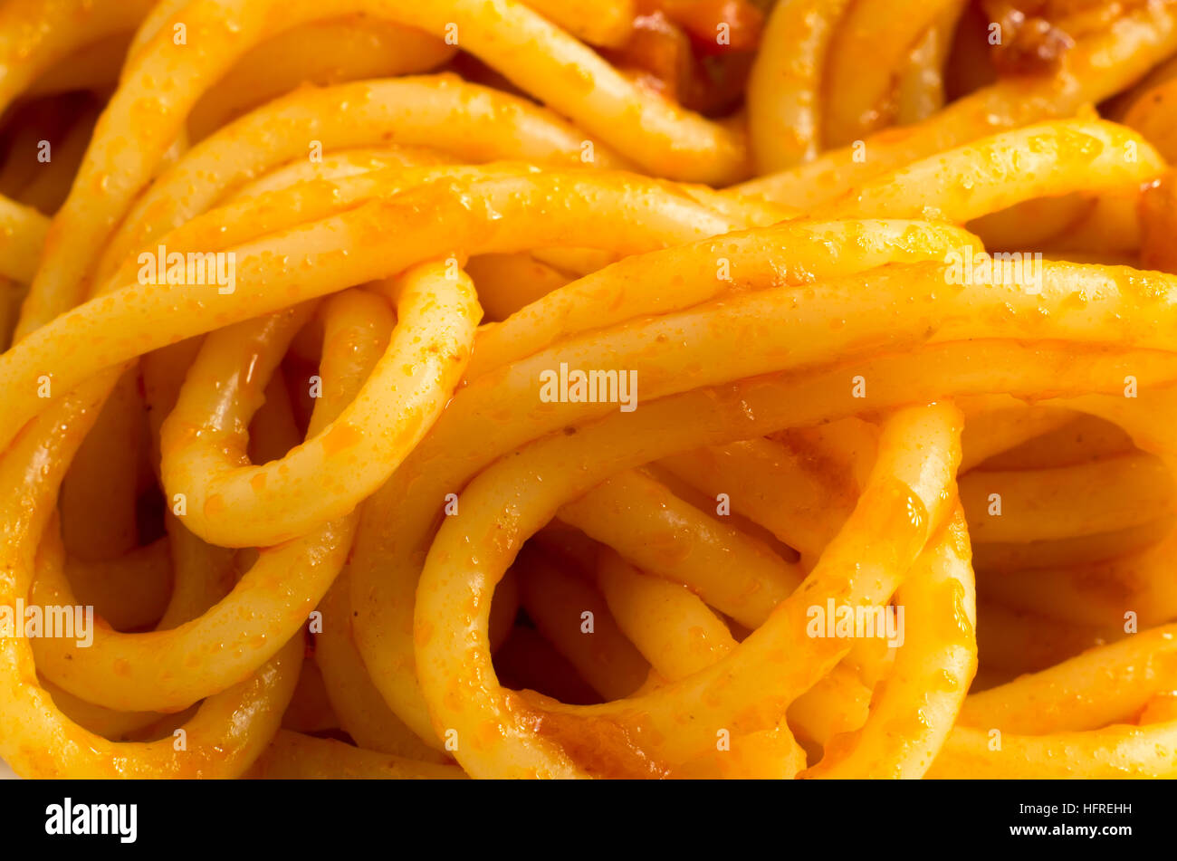 Macro view of the cooked spaghetti with yellow vegetable sauce close-up ...